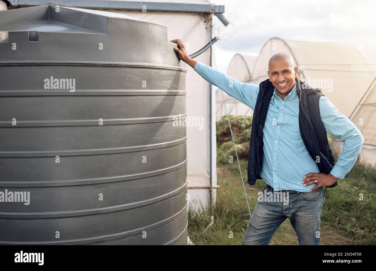 Farmer, portrait and water tank in farming liquid or soil hydration for ...