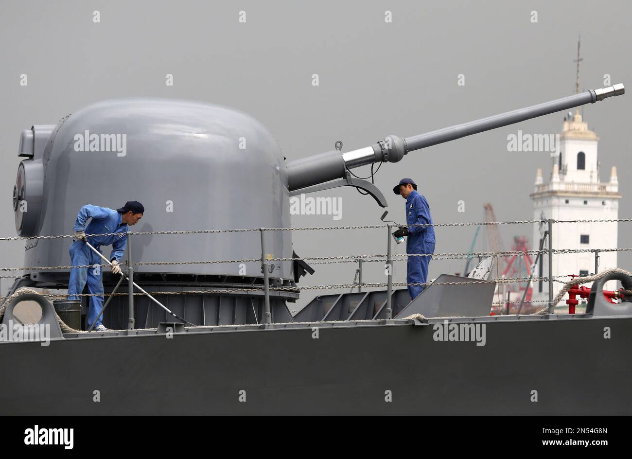 Japanese sailors clean the 76mm rapid fire gun on board the Japan ...