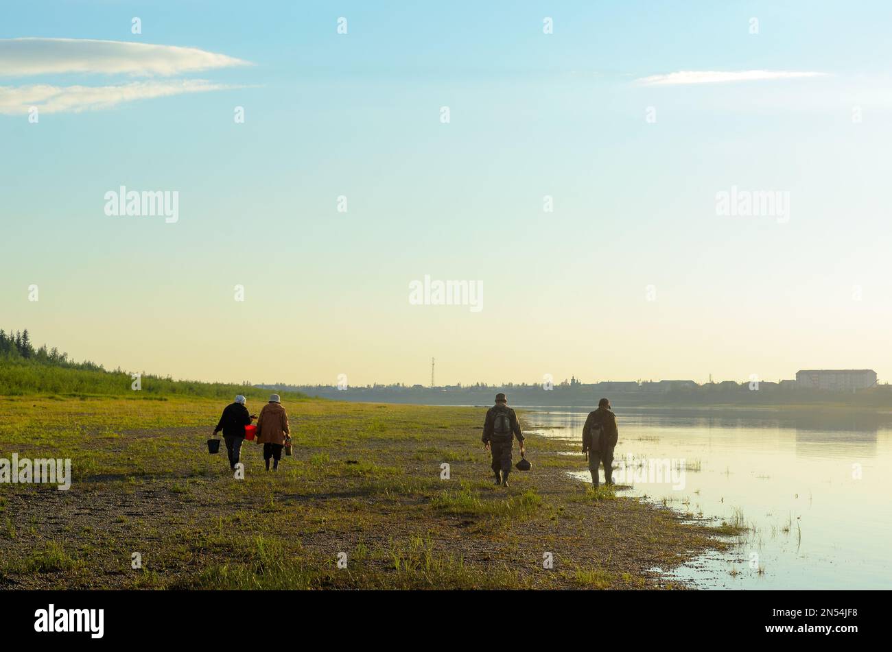 A group of men and women of Asian Yakuts with bags and buckets walking ...