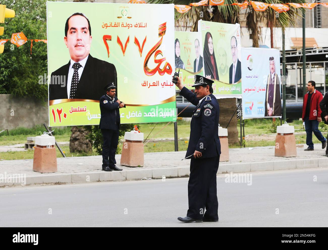Iraqi traffic police officers control traffic in front of election ...