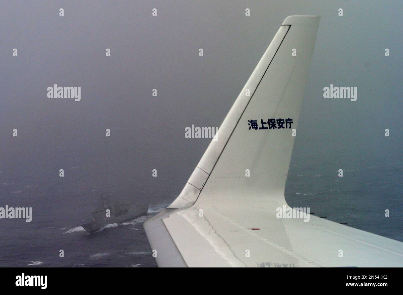 A Japan Coast Guard Gulfstream aircraft flies past HMAS Toowoomba as ...