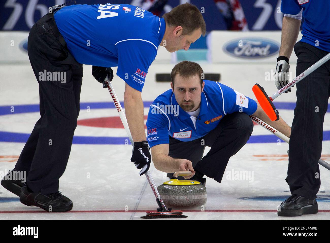 Joe Polo of the U.S. releases the stone against Canada near teammate ...