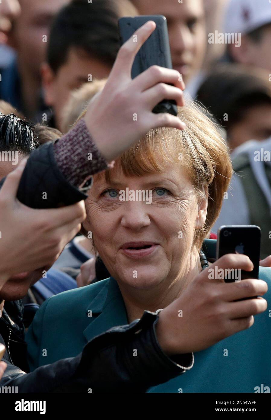 German Chancellor Angela Merkel, poses with students, taking pictures ...