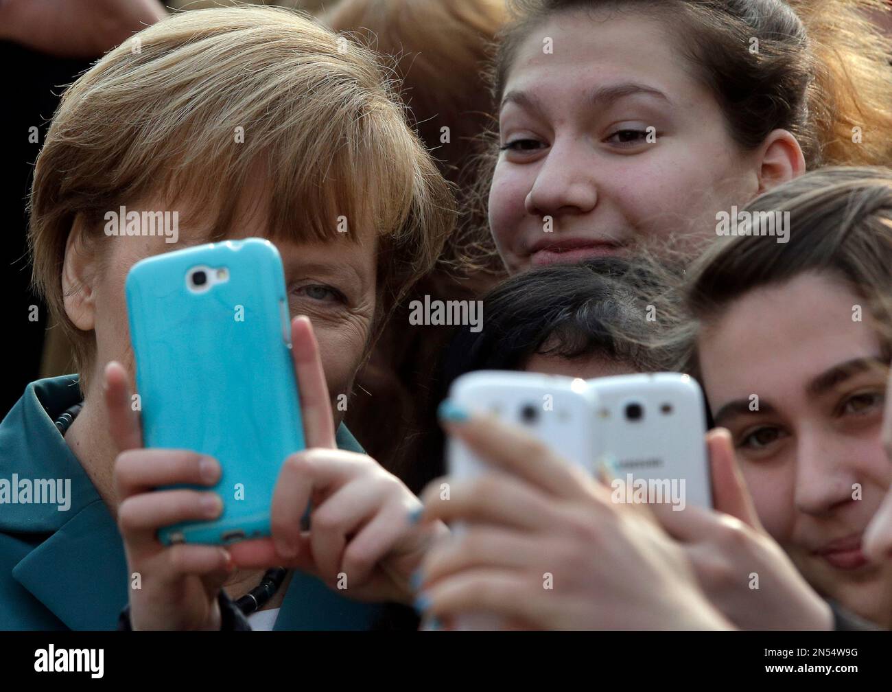 German Chancellor Angela Merkel, left, poses with students taking ...