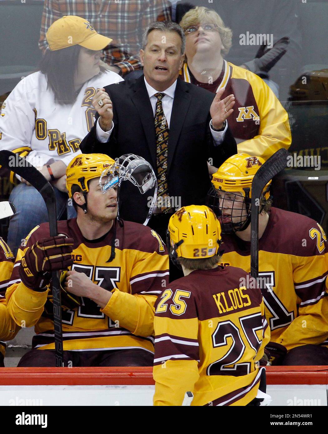 Minnesota head coach Don Lucia, top, talks with forward Justin Kloos ...