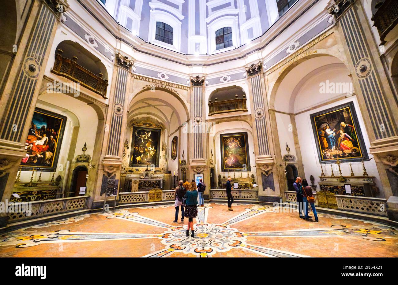 People looking at Caravaggio's painting, The Seven Works of Mercy, in ...