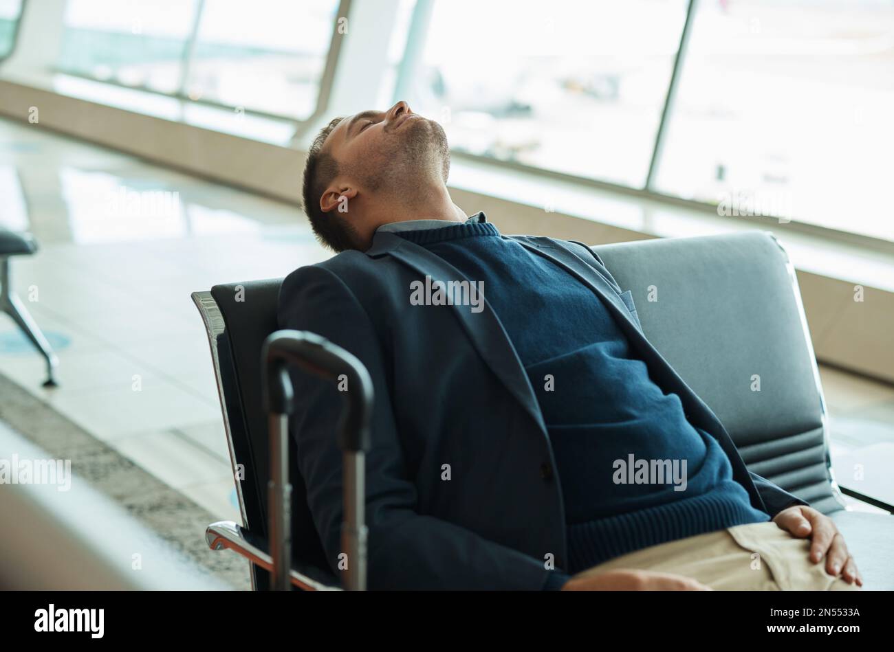 Airport, travel and tired businessman sleeping while waiting to board ...