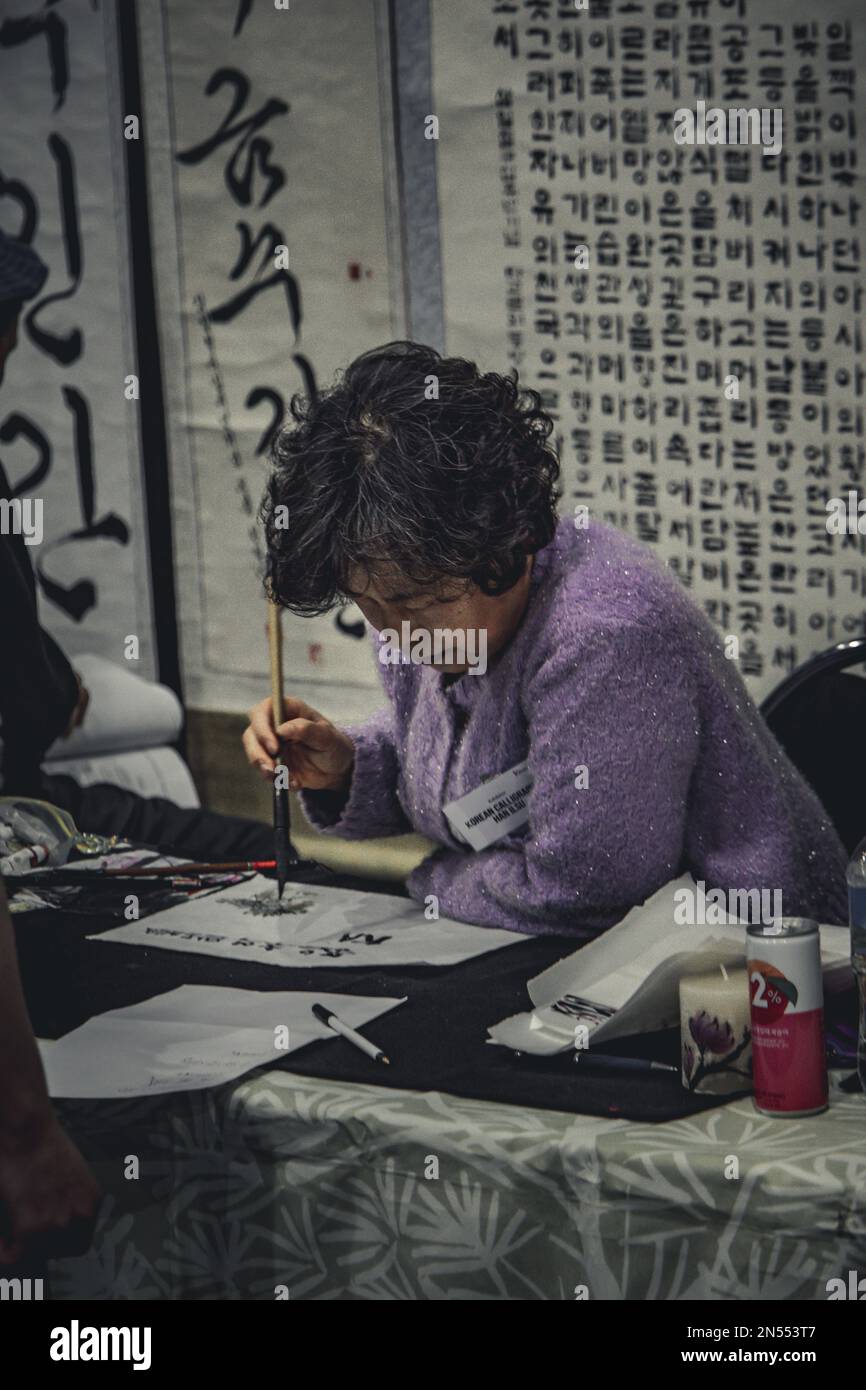 A female artist painting during the Korean Festival Auckland at trust ...