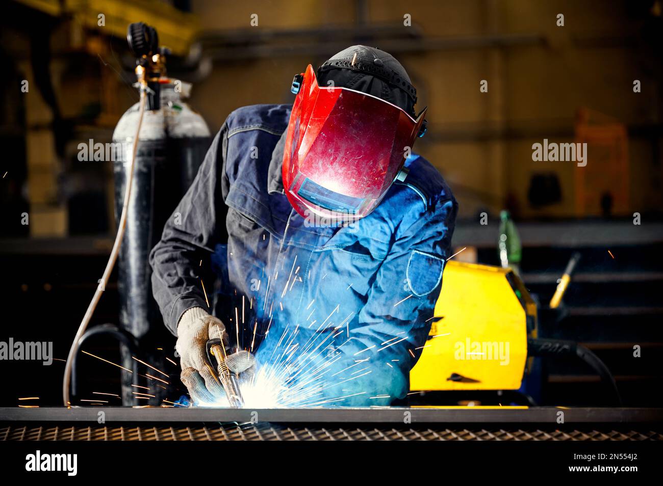 Worker with mask welds details with semi automatic machine Stock Photo ...