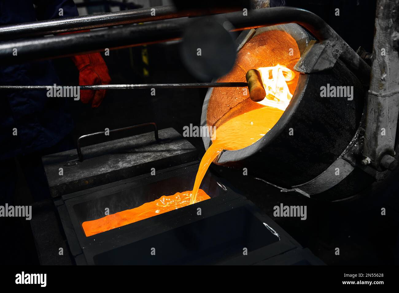 Pouring red liquid silver from bucket in induction oven Stock Photo - Alamy