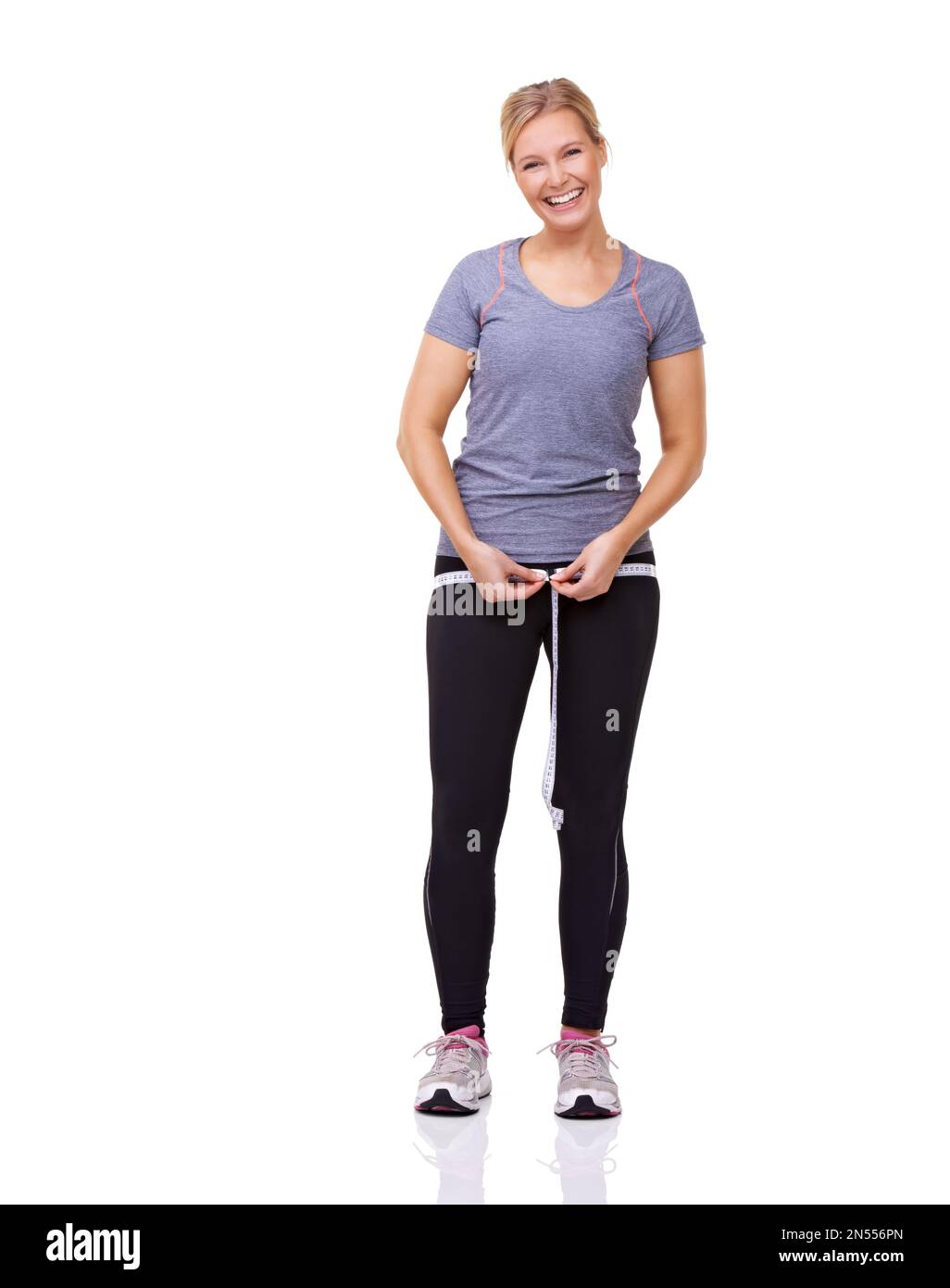 Encouraging results. Studio shot of an attractive young woman measuring ...