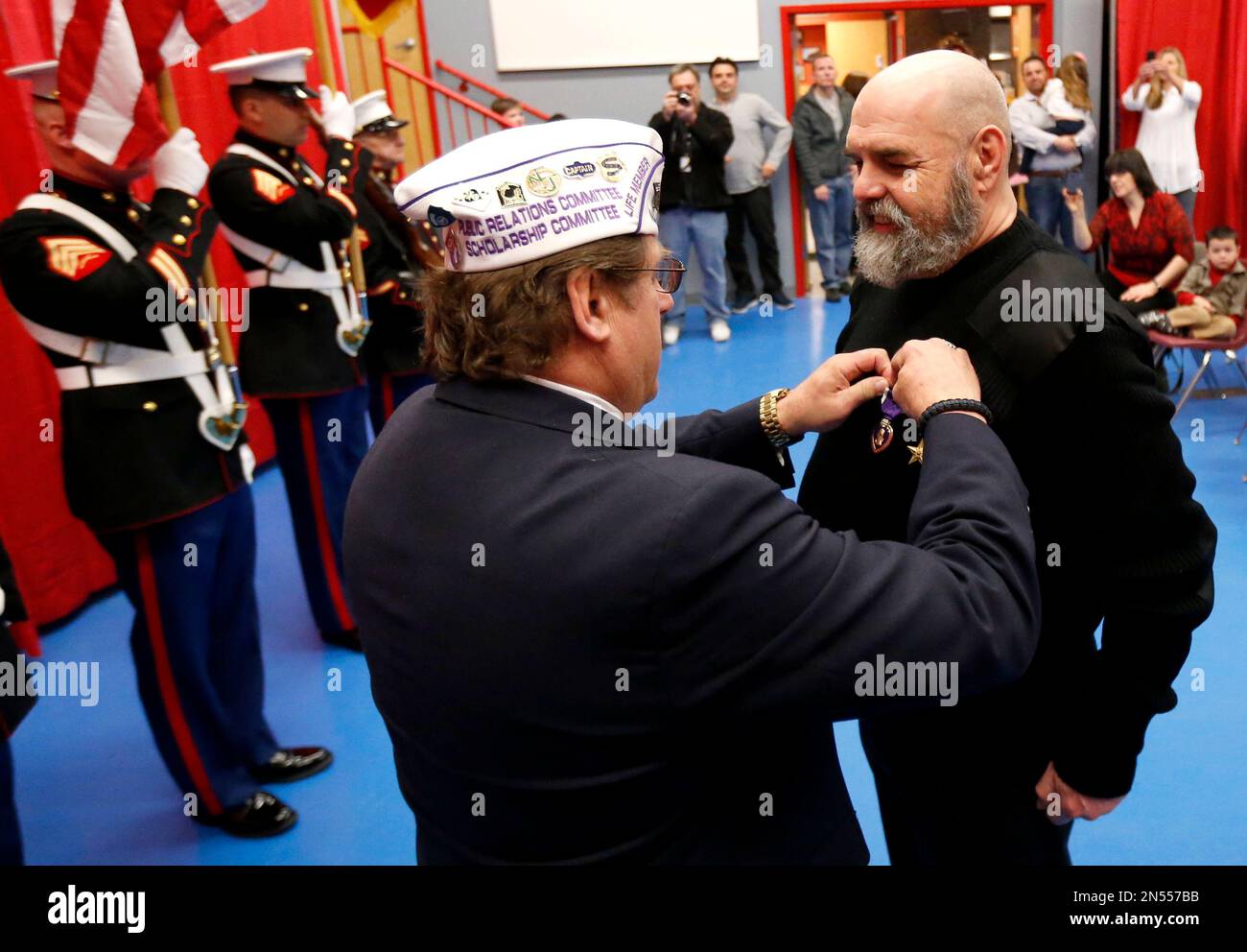 Robert Milligan, right, is pinned with the Purple Heart by Neil Van Ess ...