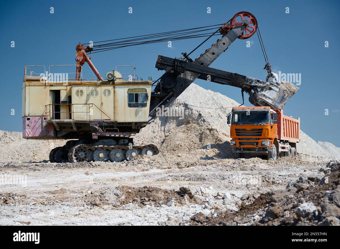 Shovel excavator loads chalk into tip truck at open quarry Stock Photo ...