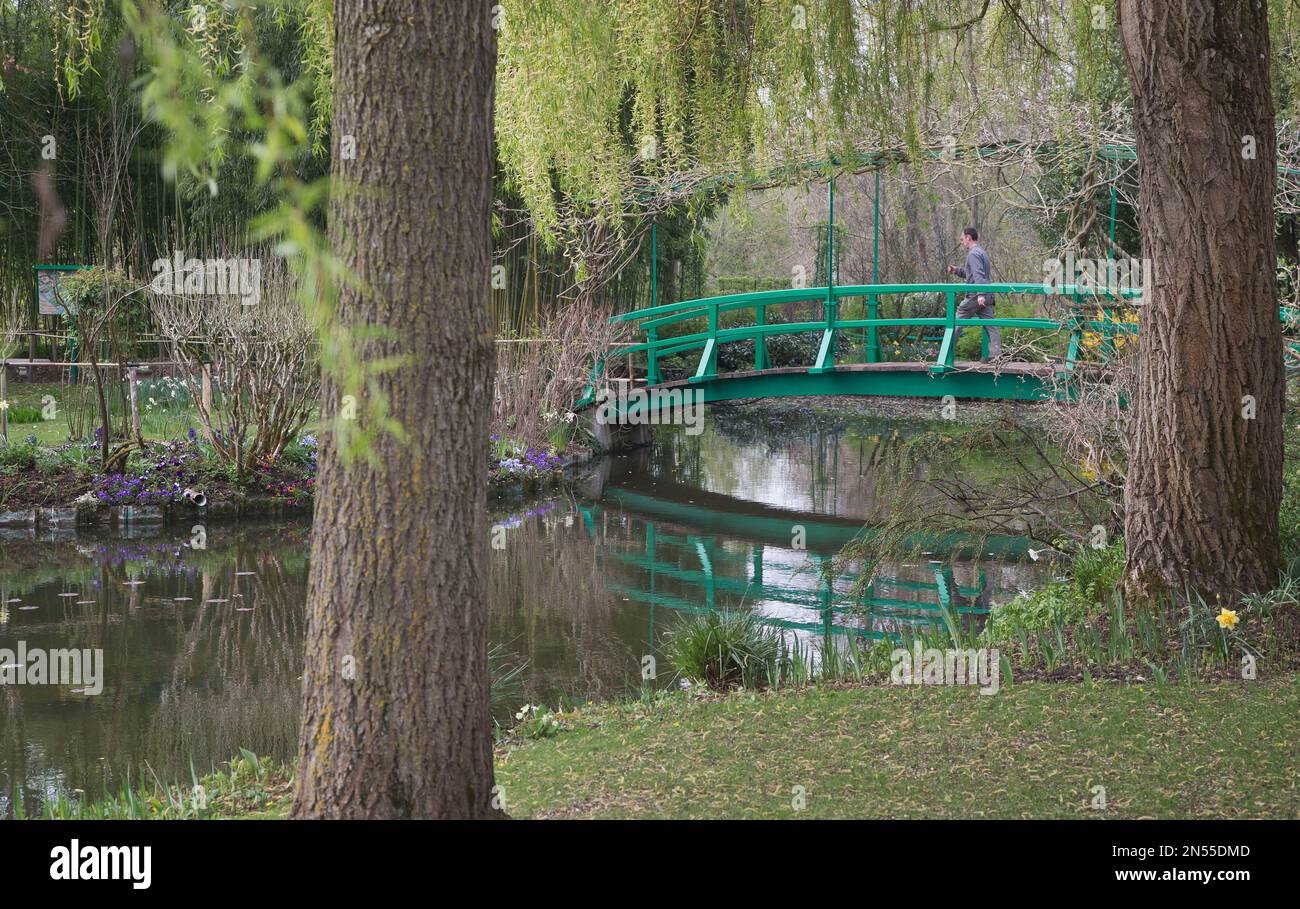 A man crosses the Japanese bridge at the waterlily pond at the Claude ...