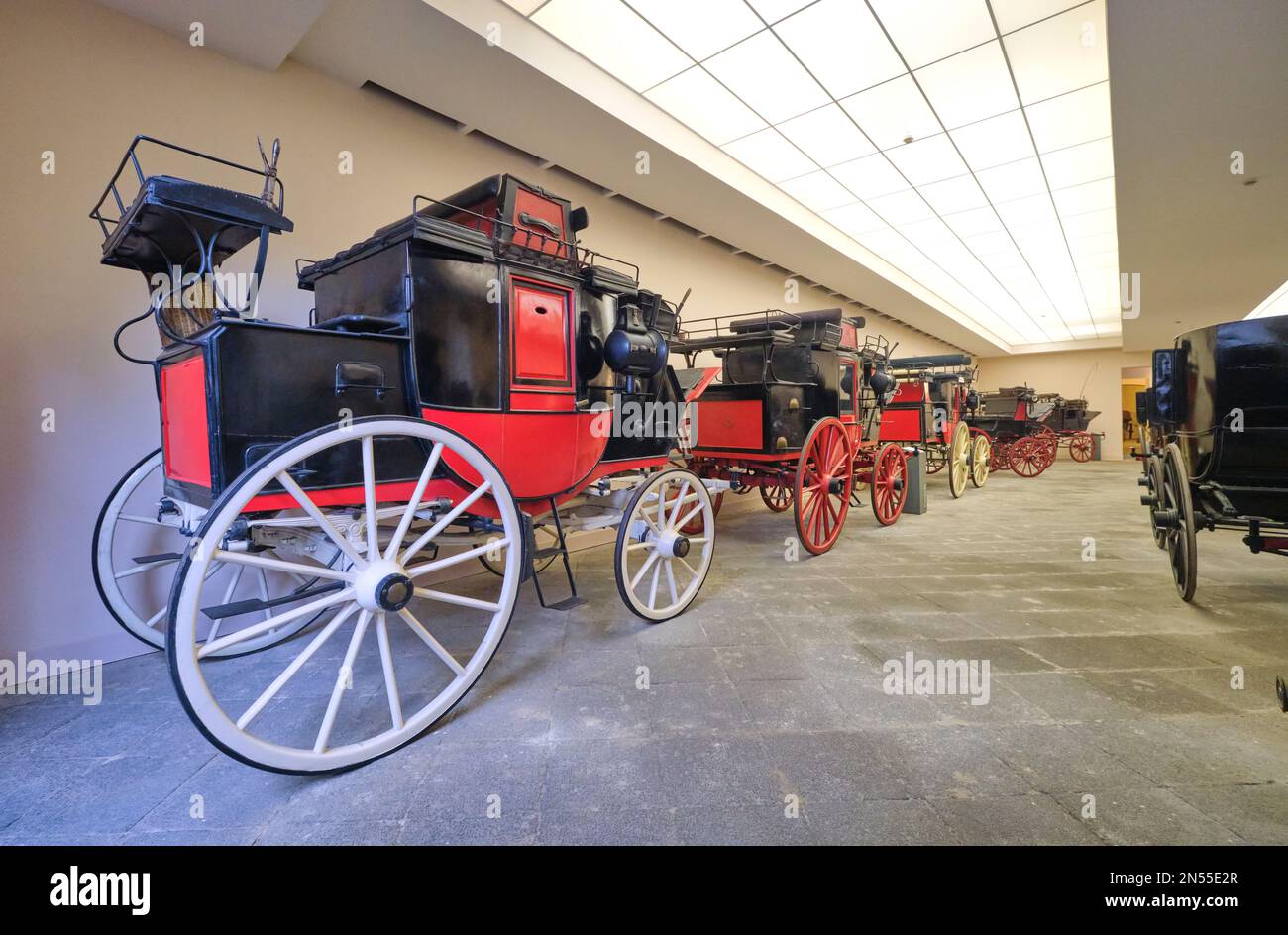 Various red horse carriages, coaches, wagons, vehicles on display. At ...