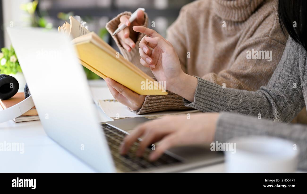 Close-up image of two Asian female marketing workers discussing ...
