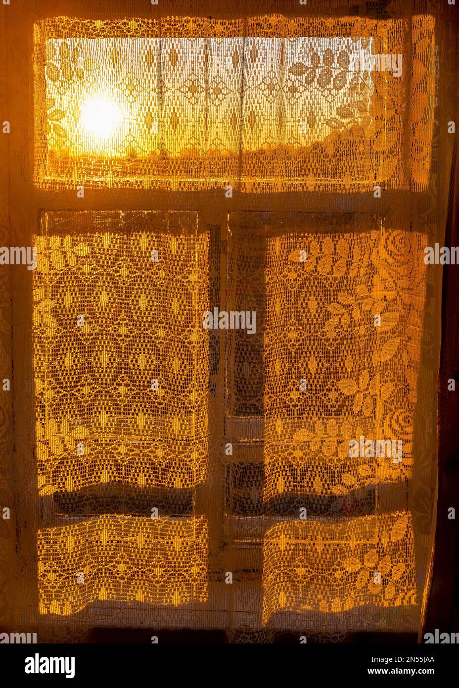 The bright yellow sunlight from the sunset over the horizon comes ...