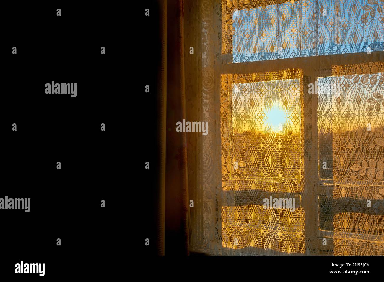 The bright yellow sunlight from the sunset over the horizon comes ...