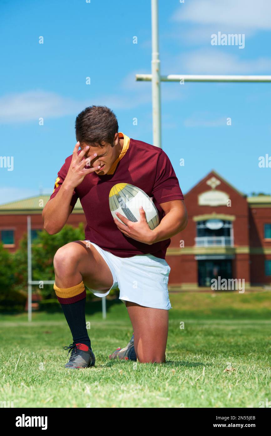 Its a mans sport. Full length shot of a young rugby kneeling on the ...