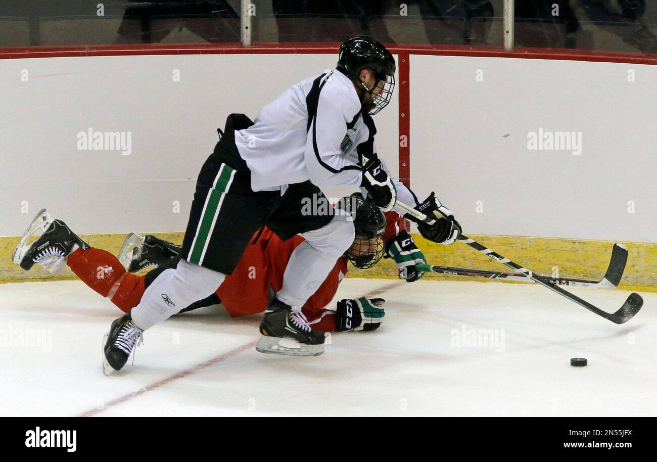 North Dakota defenseman Keaton Thompson, front, takes the puck past ...