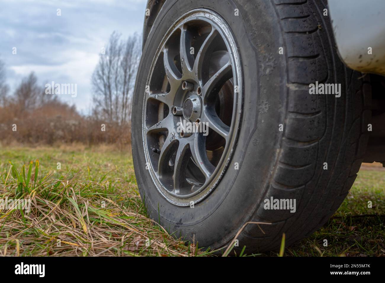 Wheel tyre SUV crossover stands on the ground with grass on the ...
