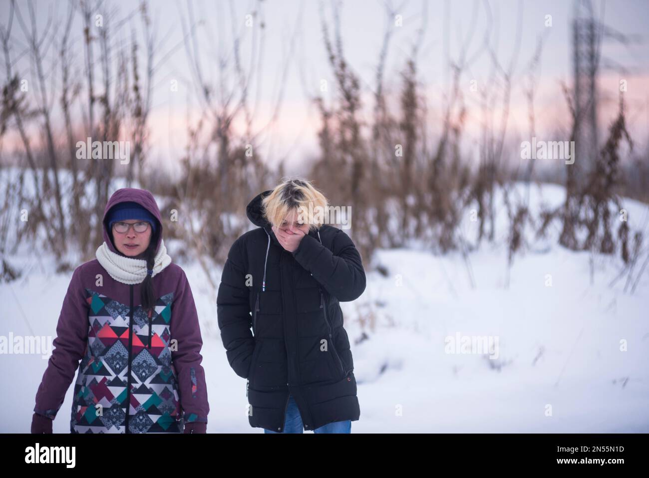 A fashionable young man with colored hair without a hat in winter warms ...