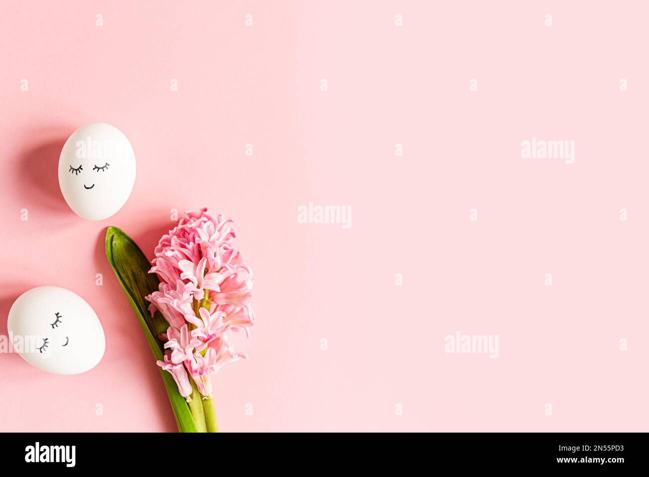 Creative easter eggs with cute face and sleepy eyes on pastel pink ...