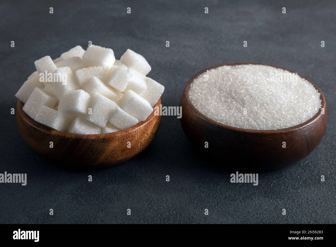 Cube sugar and granulated sugar on dark background,closeup Stock Photo ...
