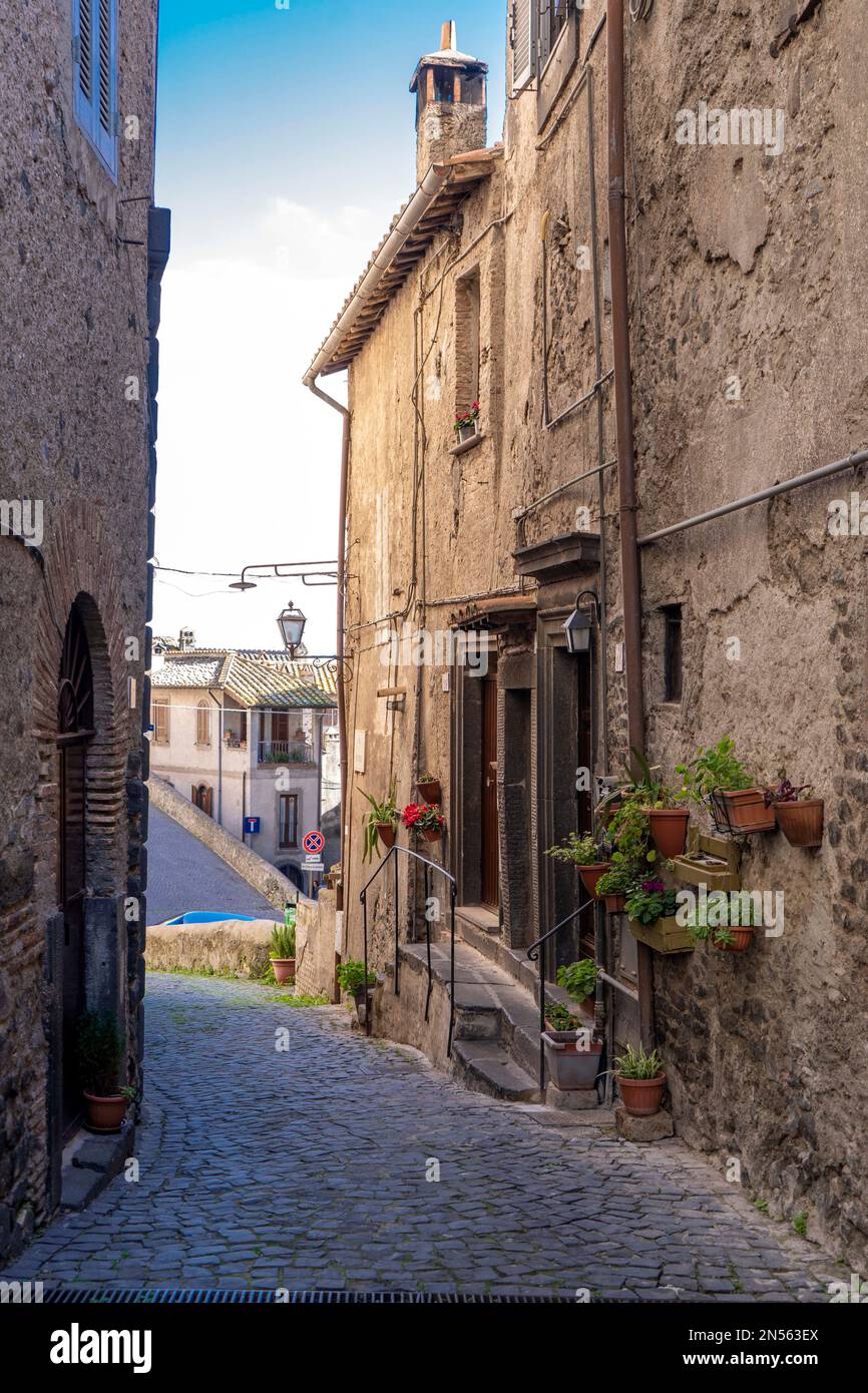 A vertical shot of a narrow paved street passing through old medieval ...