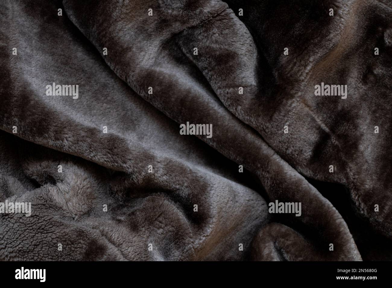 Background of a black men's sheepskin coat made of faux fur, fur ...