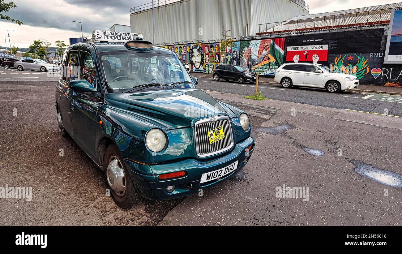 Taxi, Black Cab, parked in front of a wall with murals, Northern ...