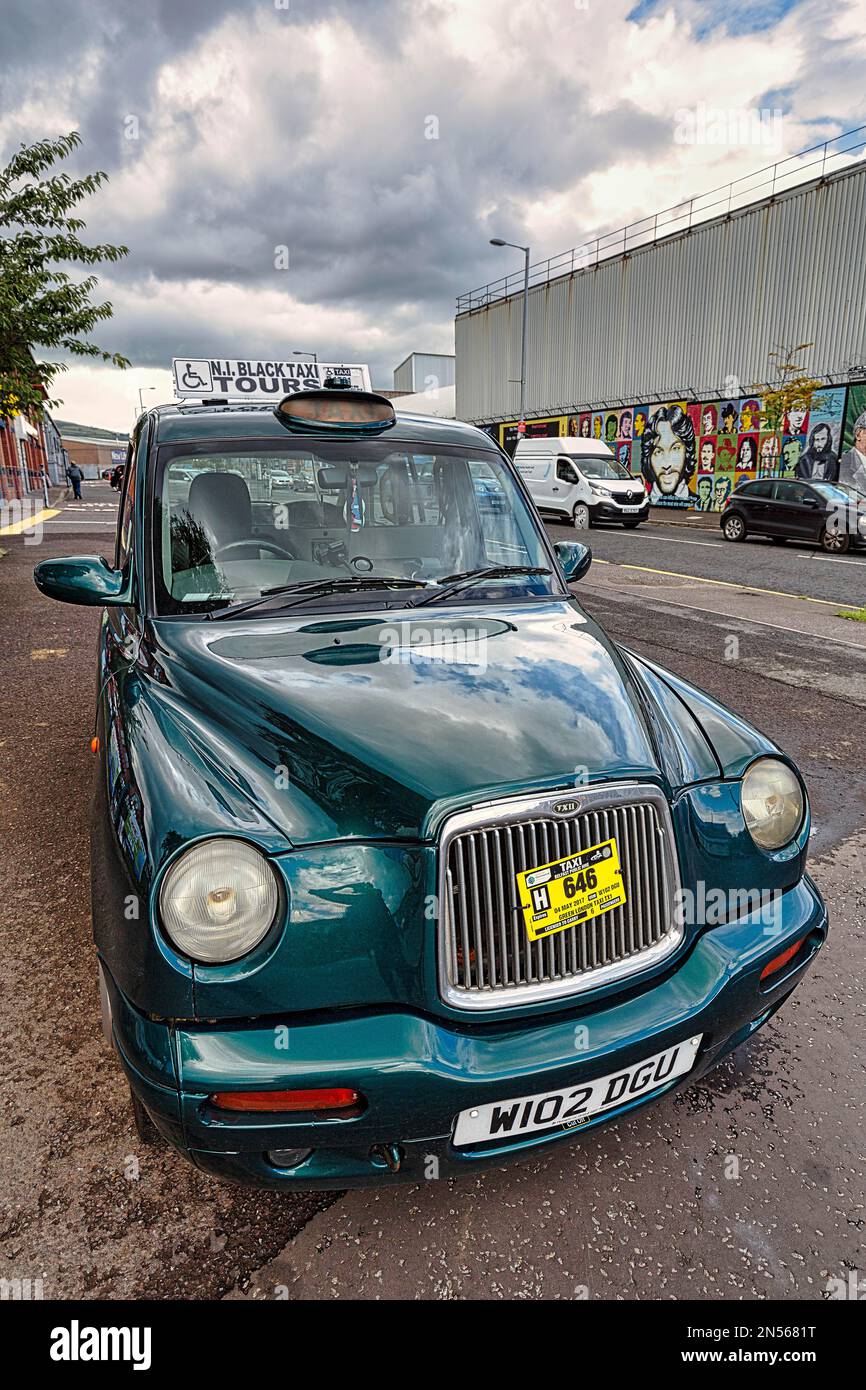Taxi, Black Cab, parked in front of a wall with murals, Northern ...