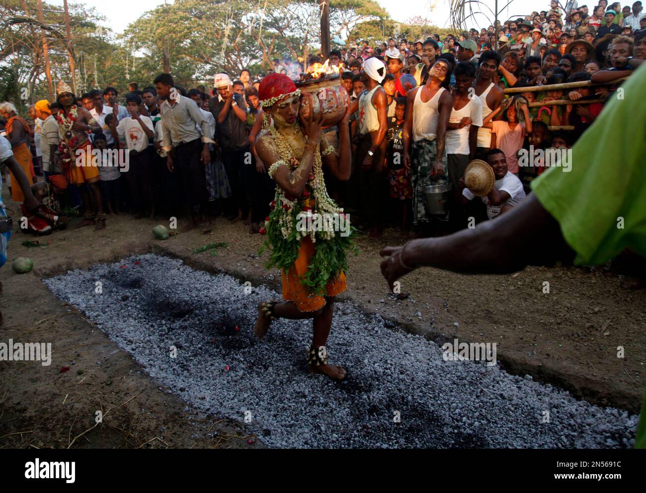 In this Sunday, March 23, 2014 photo, a Hindu devotee carrying a fire ...