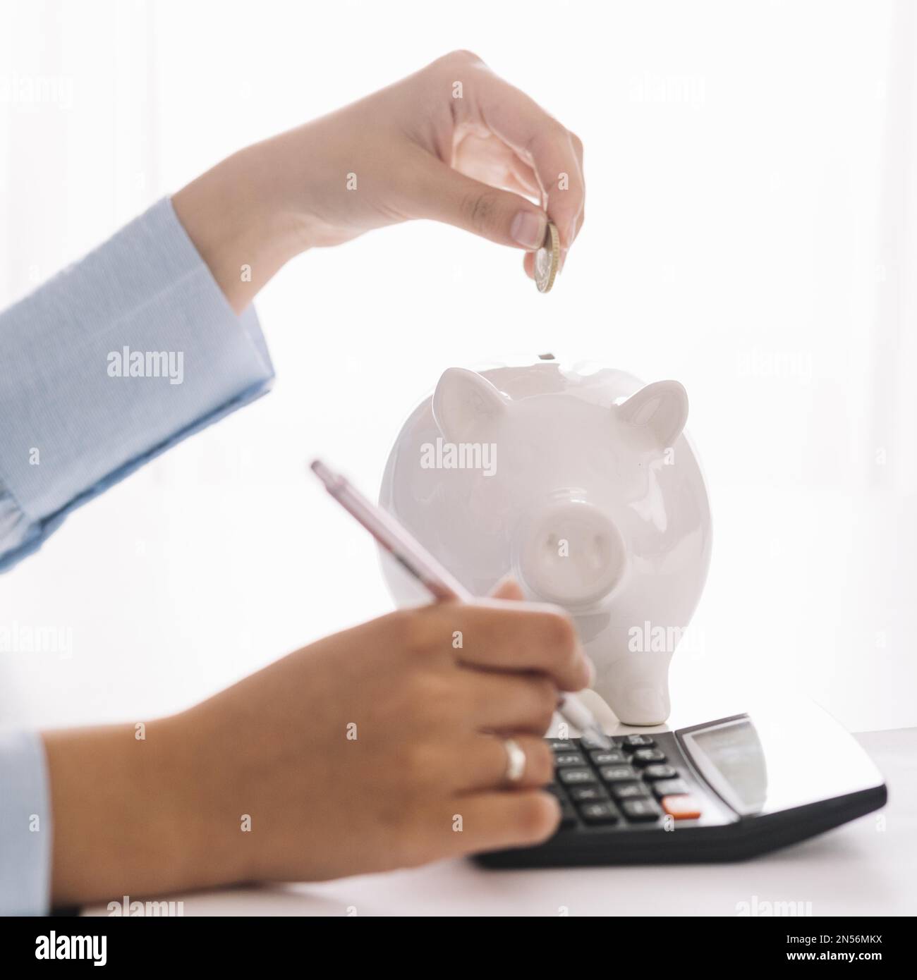 woman s hand using calculator while inserting coin piggybank. Resolution and high quality ...
