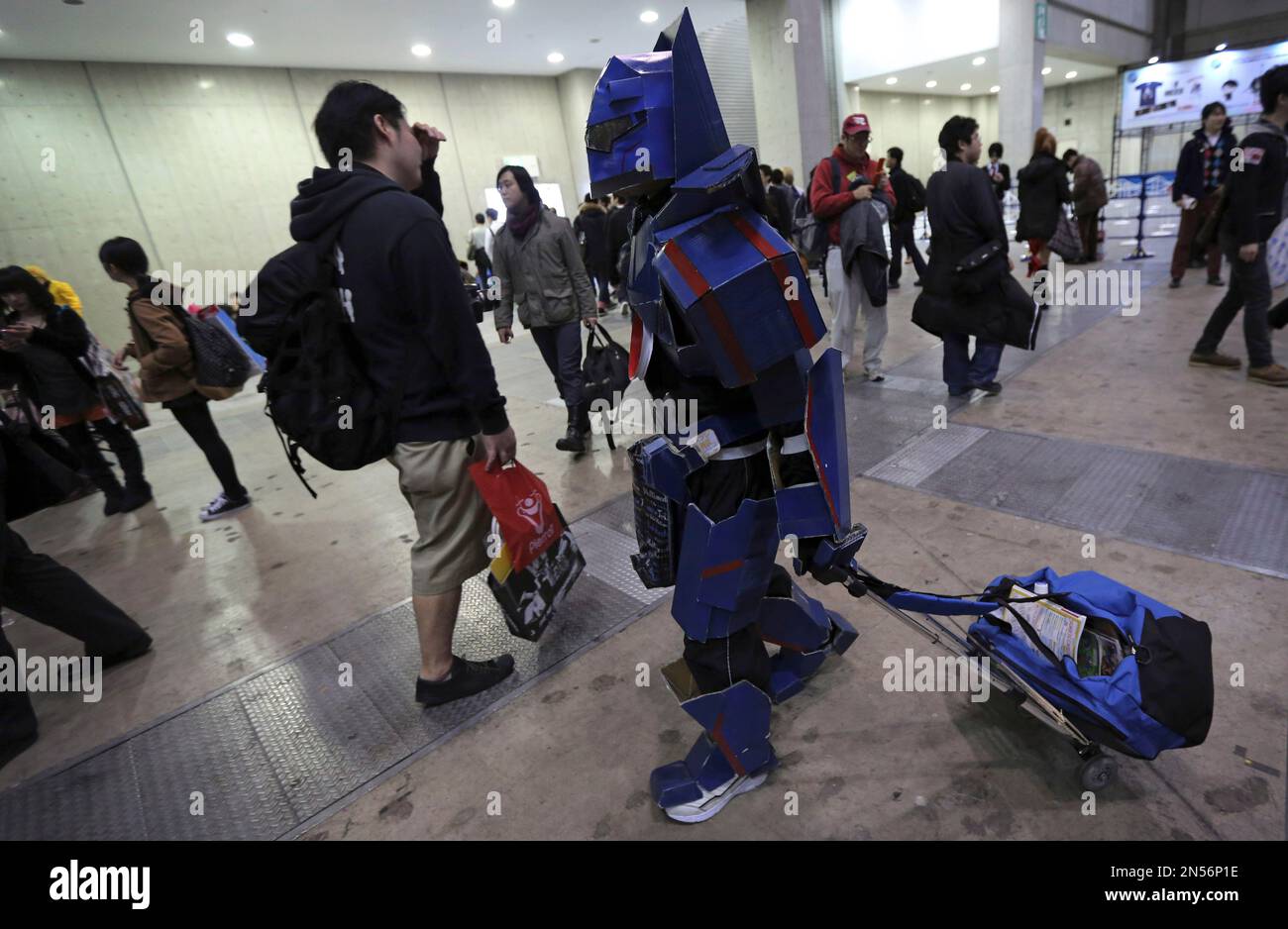 A costume player, or cosplayer, with cardboard-made robot costume walks ...
