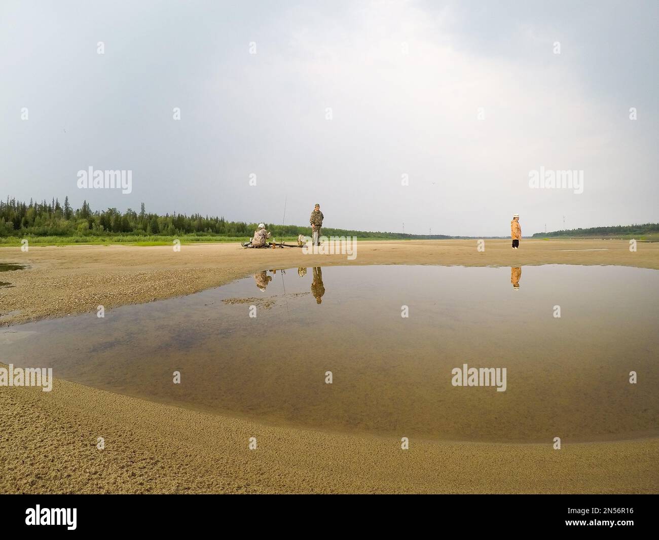 Three Asian Yakuts settled down to rest on the banks of the river at ...