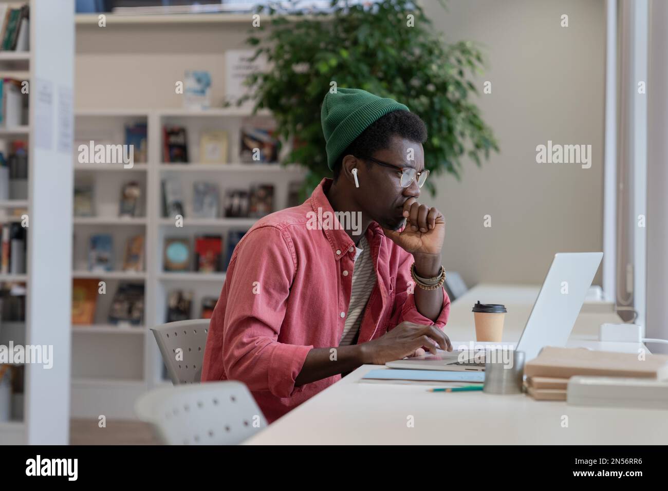 Focused young African man tutor teacher looking at laptop preparing for ...