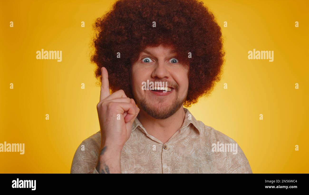 Eureka. Inspired man with lush Afro hairstyle coiffure pointing finger ...