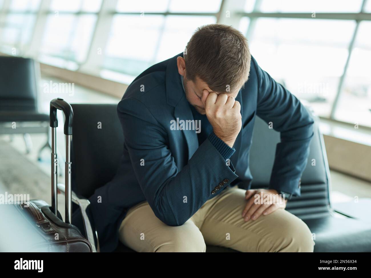 Airport, headache and stress man waiting to travel, frustrated and sad ...