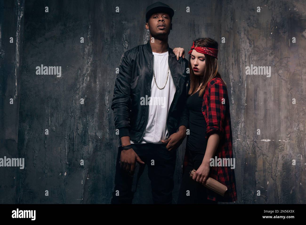 Gang members couple with gun and bottle Stock Photo - Alamy