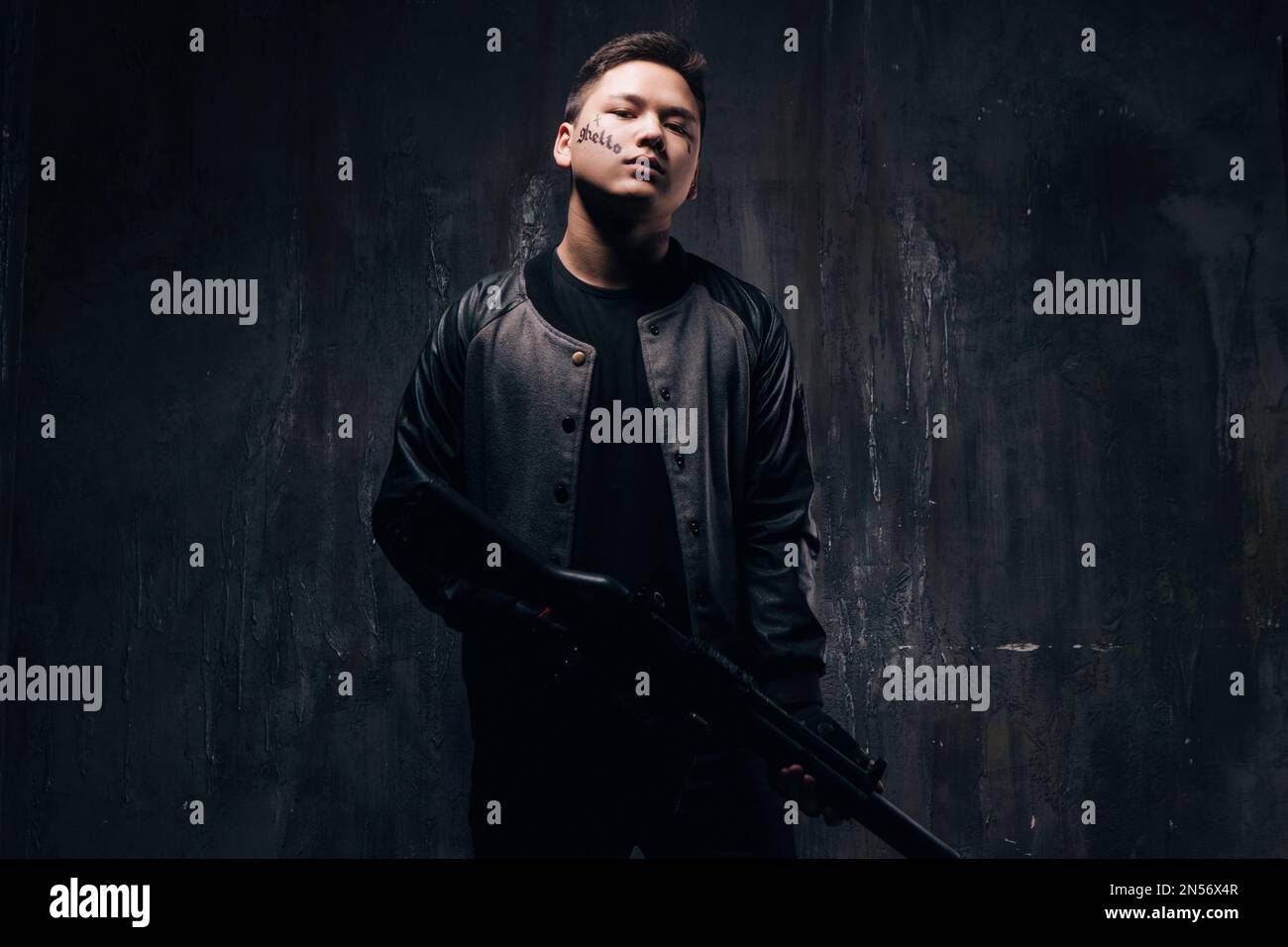 Tattooed outlaw man with sniper rifle in black Stock Photo - Alamy