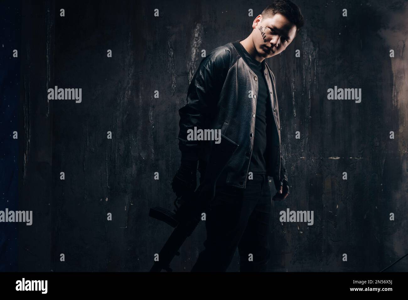 Tattooed killer with sniper rifle in black Stock Photo - Alamy