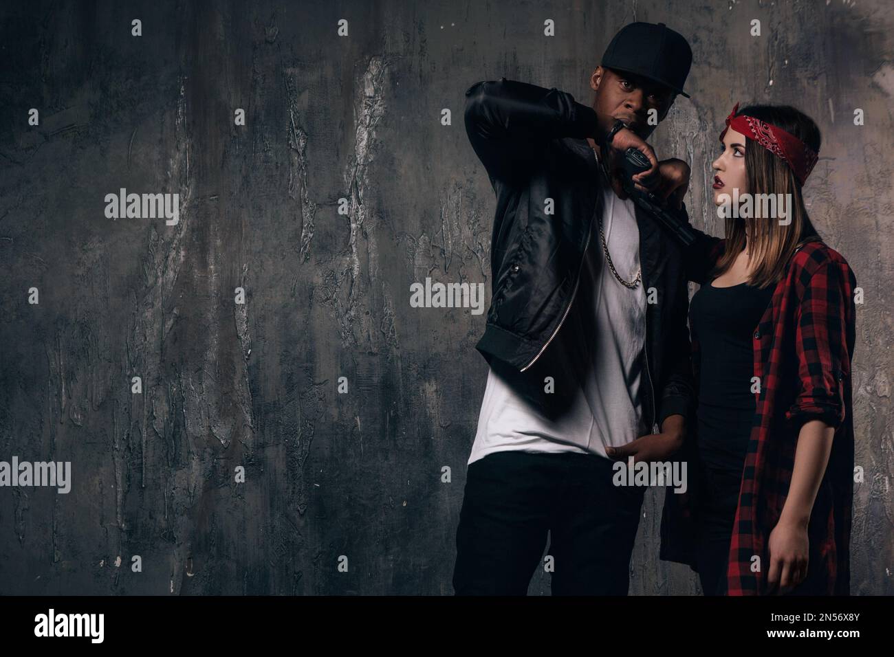 Gang members couple with gun Stock Photo - Alamy