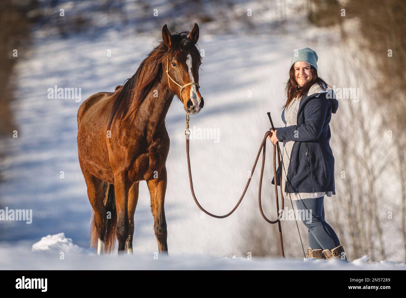 Portrait of an equestrian woman riding on her horse in front of a rural ...