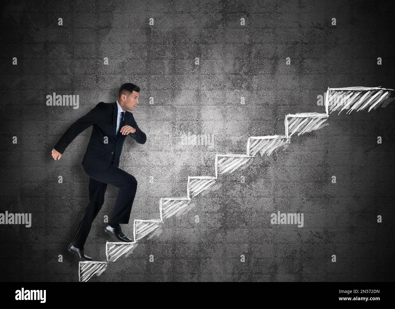 Businessman walking up stairs drawing with chalk on dark background ...