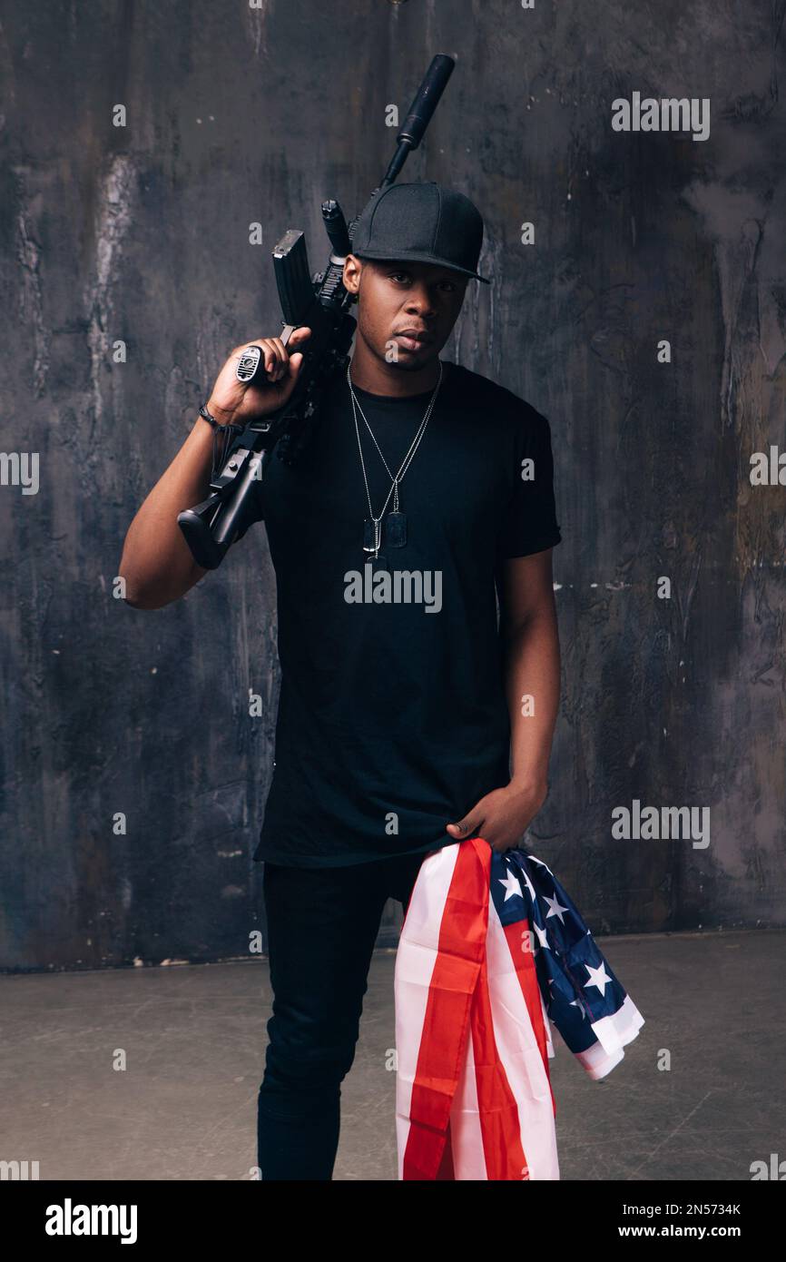 Armed black man with flag and weapon Stock Photo - Alamy