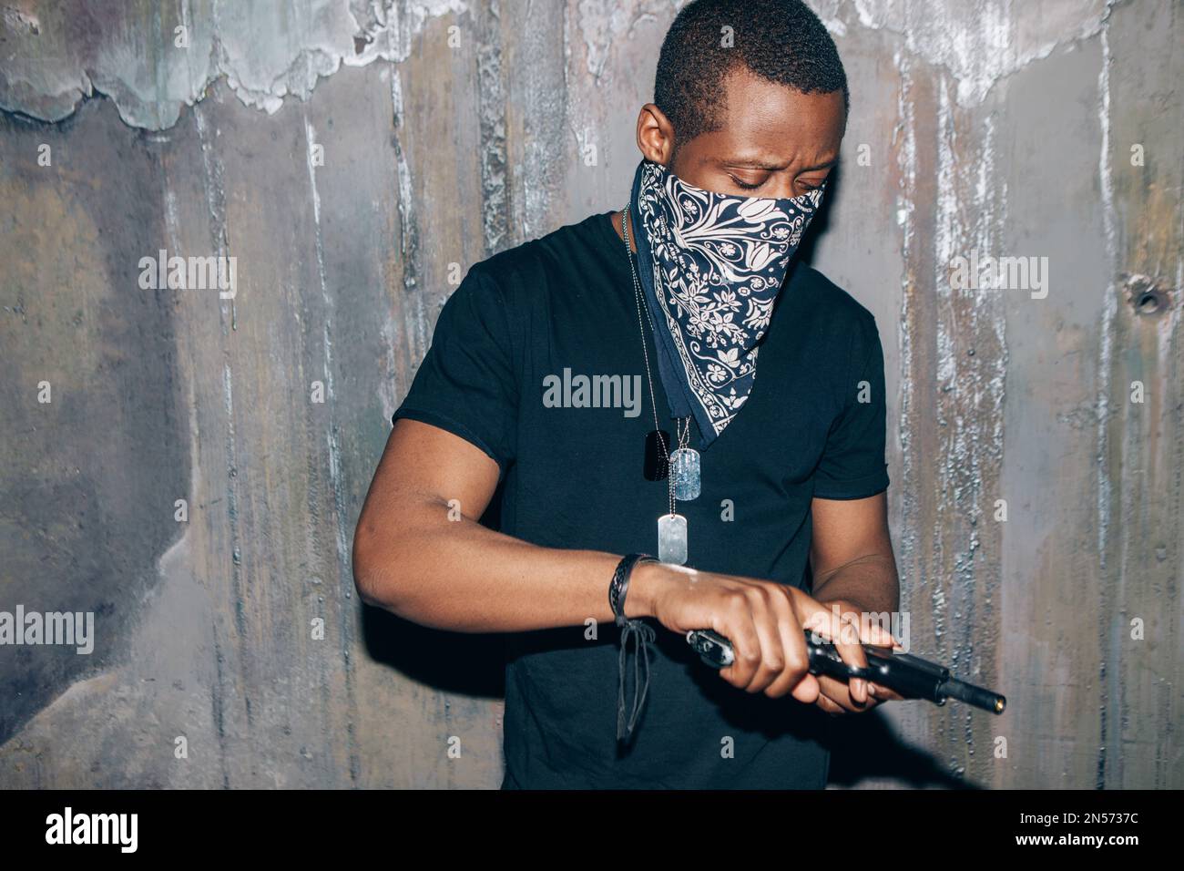 Black gang member checks his weapon Stock Photo - Alamy