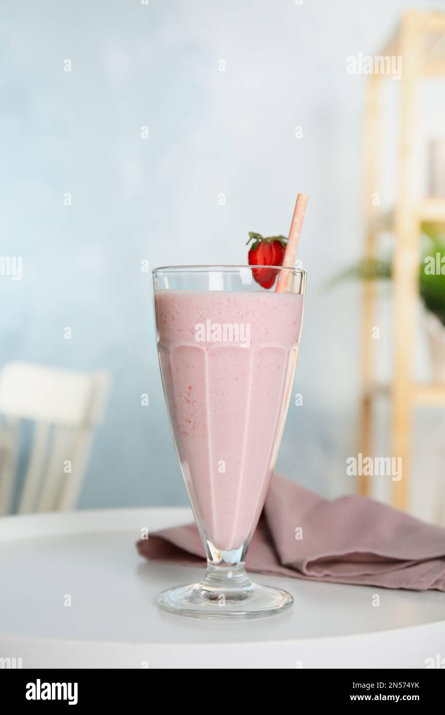 Tasty fresh milk shake with strawberry on white table indoors Stock ...