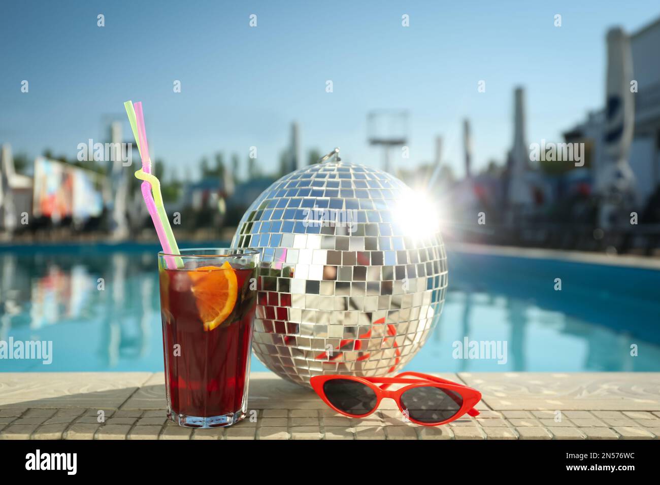 Shiny disco ball, refreshing cocktail and sunglasses on edge of ...