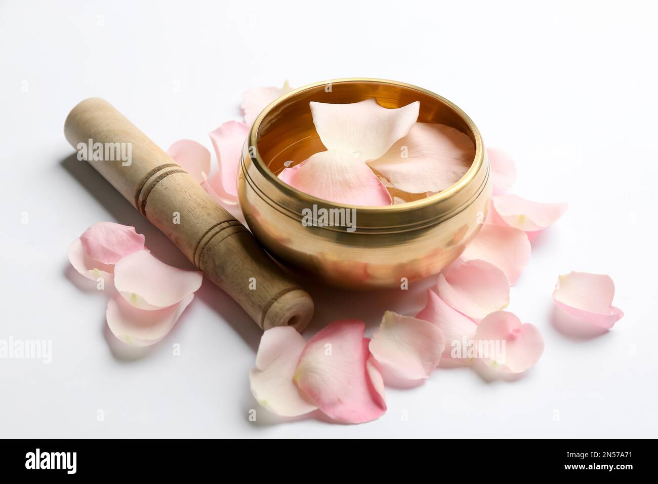 Golden singing bowl with petals and mallet on white background. Sound ...